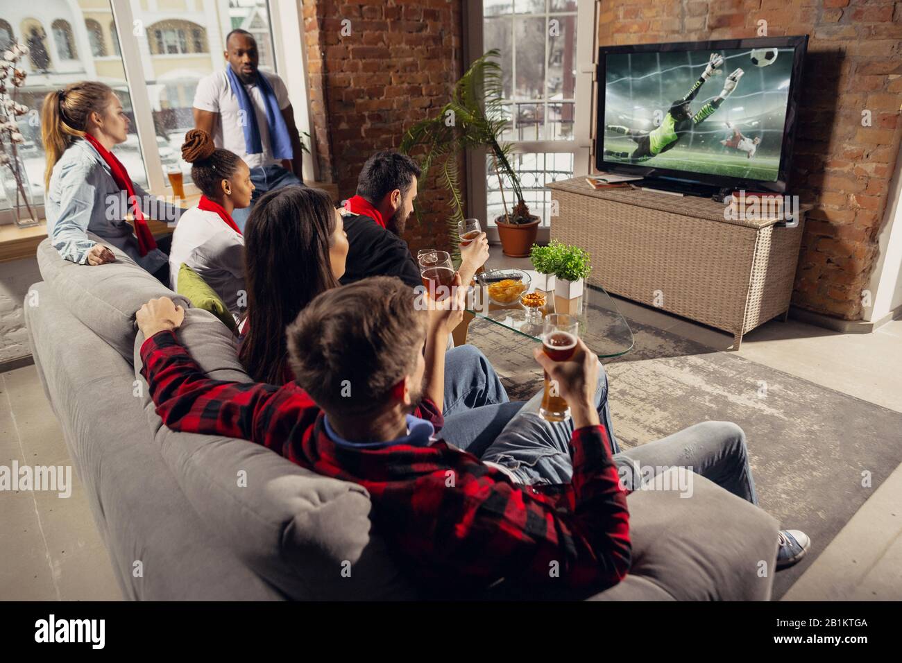 Excited group of people watching football, soccer sport match at home ...
