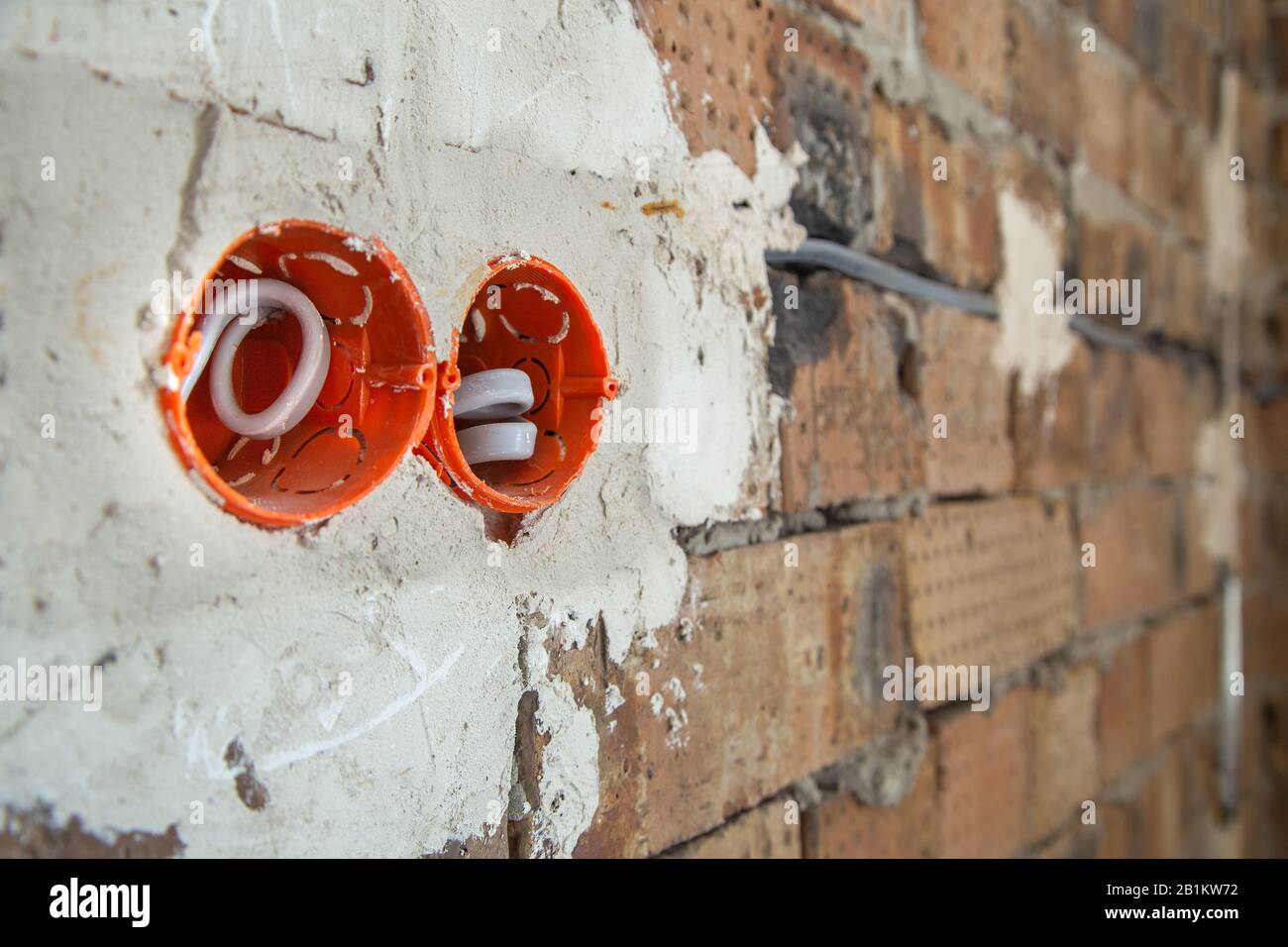 Socket orange boxes with wires in a wall. Cabling installation of ...