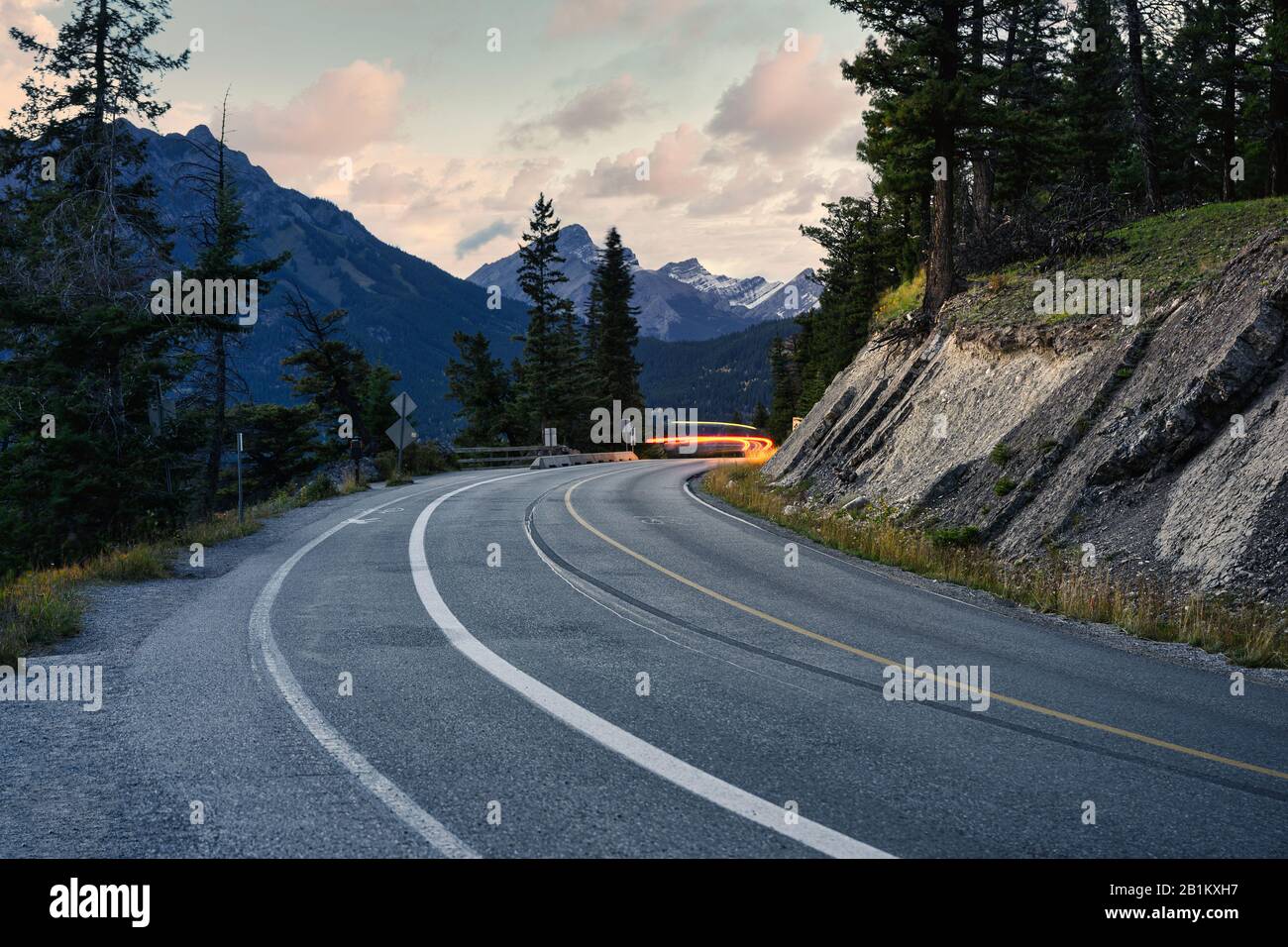 Light car on highway with rocky mountains in Banff national park at ...