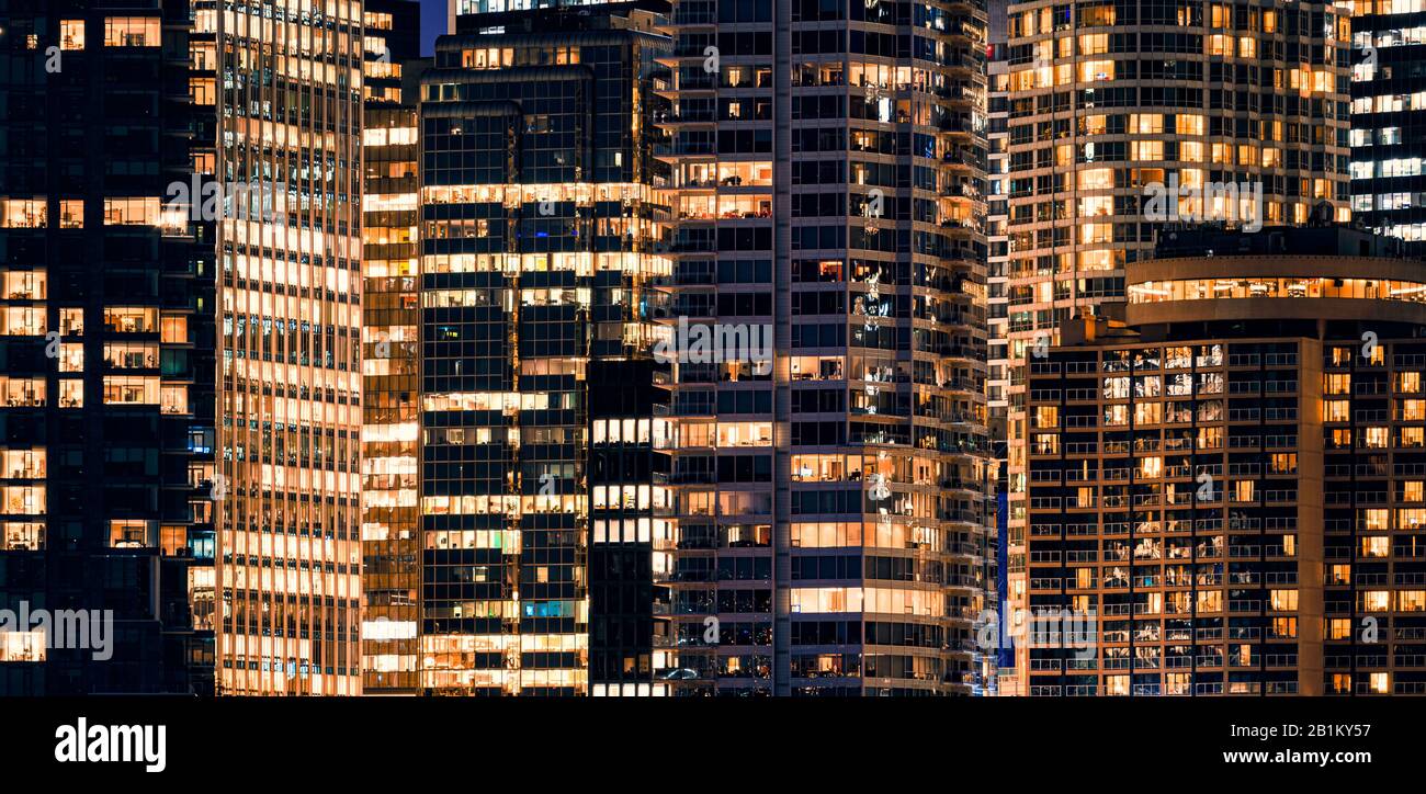 Panorama Facade windows of illuminated modern skyscraper with office ...