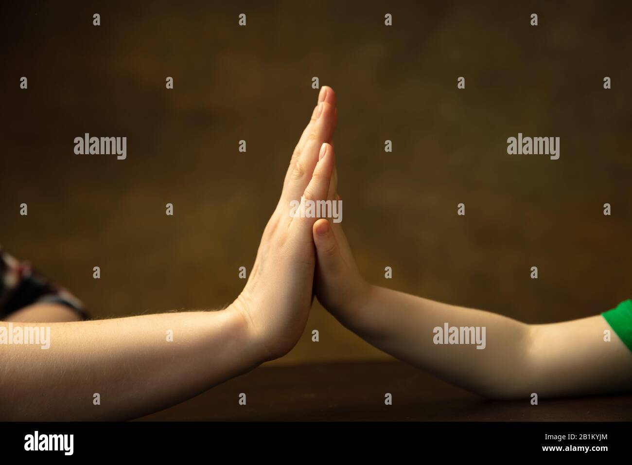 Holding hands, clapping like friends. Close up shot of female and kid's ...