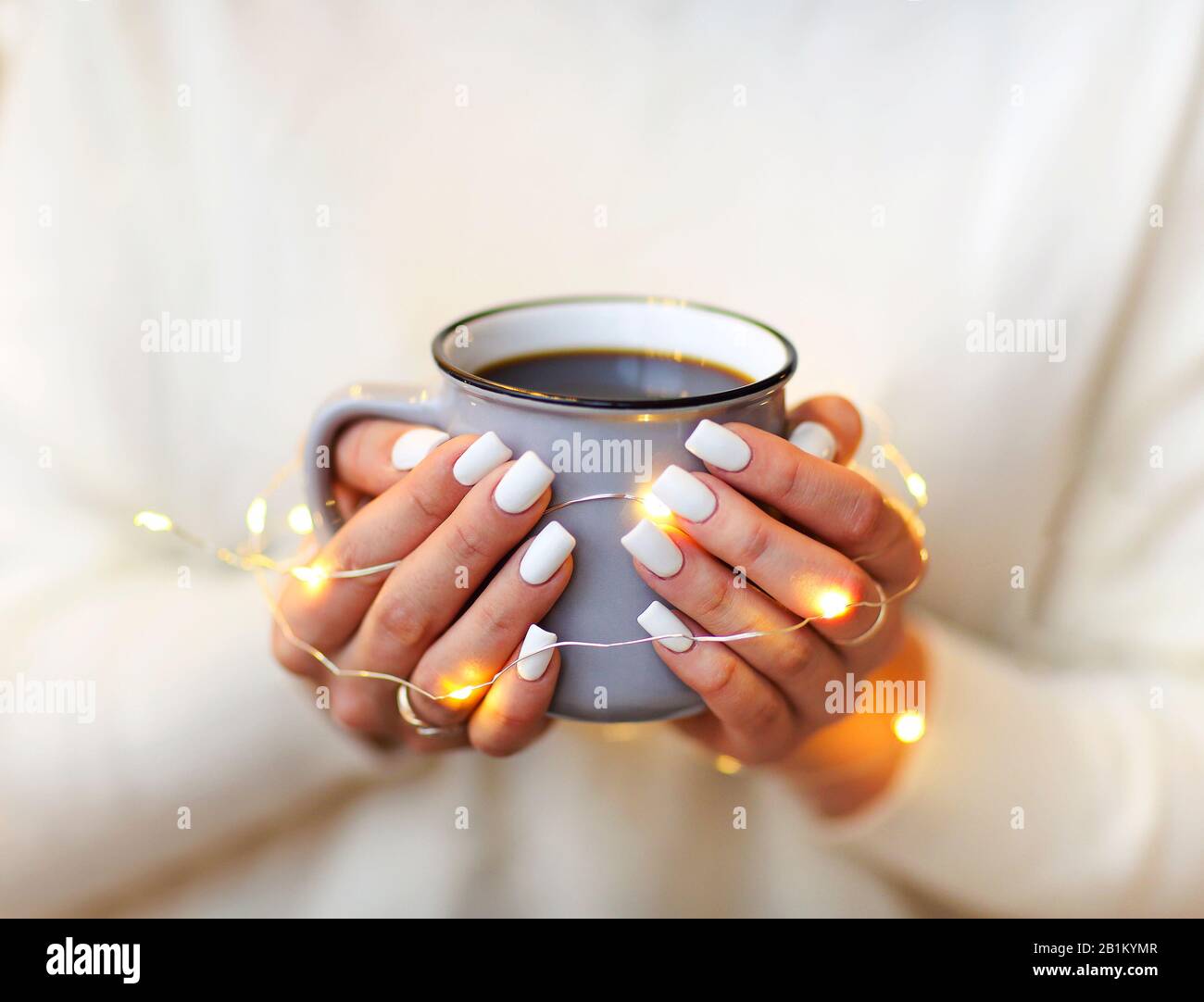 Faceless female holding mug of coffee warming hands wrapped in burning ...