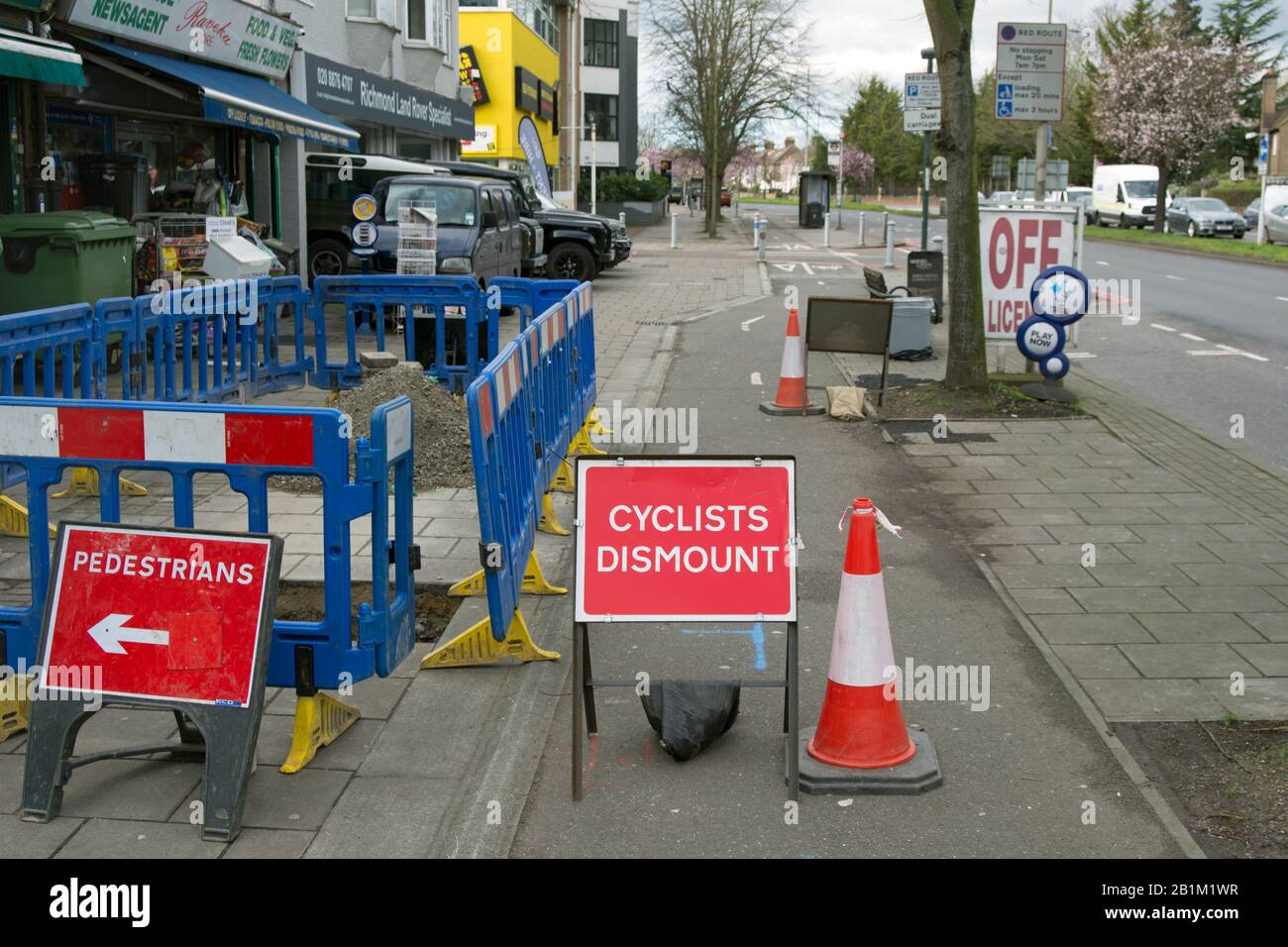 red and white cyclists dismount sign on a short stretch of unobstructed ...