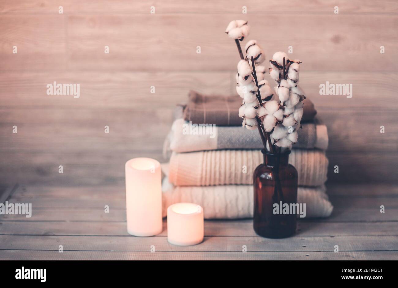 Burning white candles in composition with bouquet of ripe fluffy cotton ...