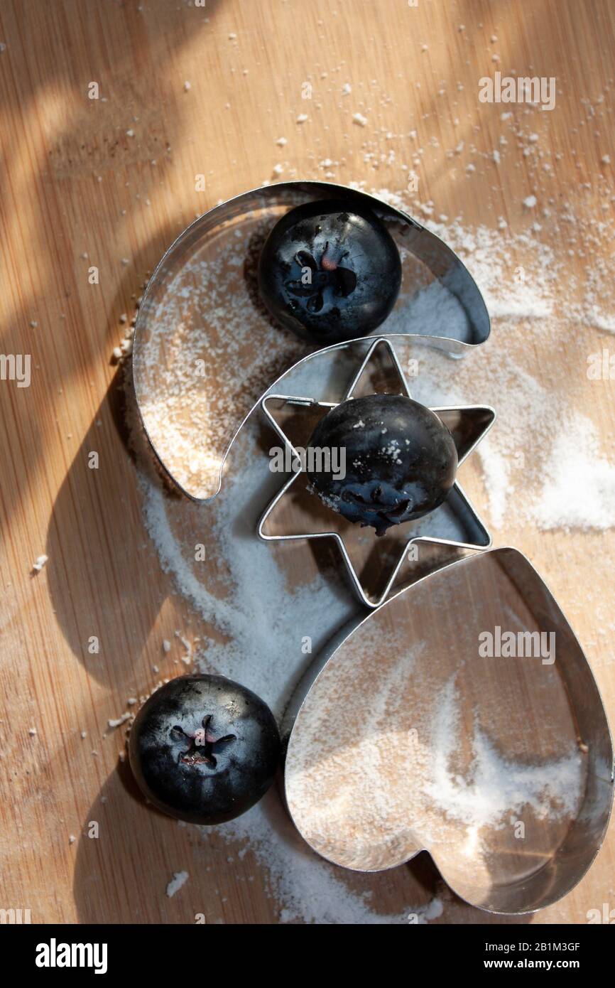 Blueberries eaten between moon and heart star figures that pose on ...