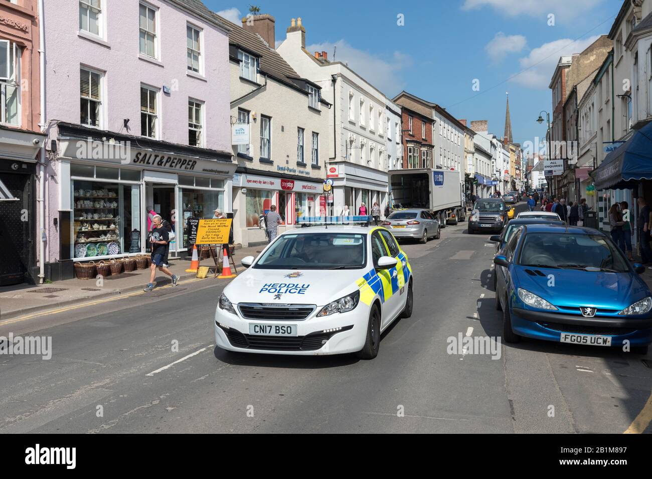 Heddlu police car driving through main shopping street, Monmouth, Wales ...