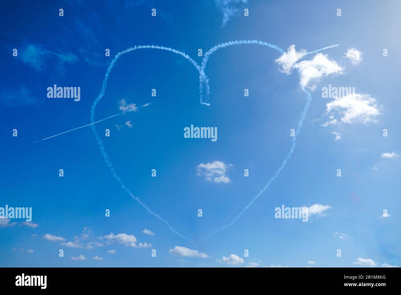 Plane doing acrobatic formation and creating a heart shape in the blue ...