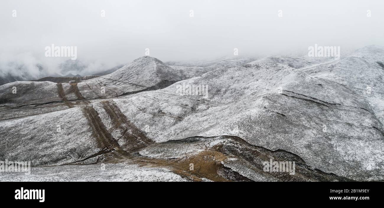Country road winding through a valley surrounded by snowy mountains ...