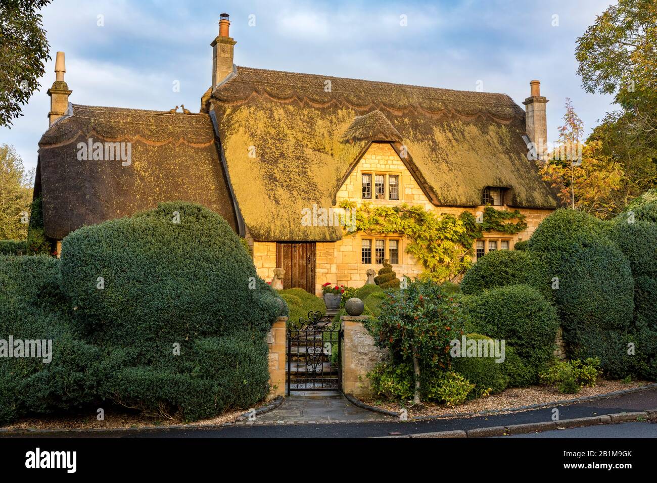 Evening Sunlight On Thatched Roof Cottage Near Medieval Cotswold Town