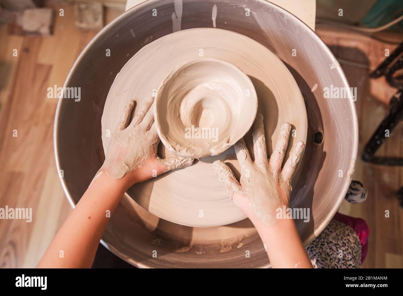 hands of young artist shaping clay on pottery wheel at workshop in ...