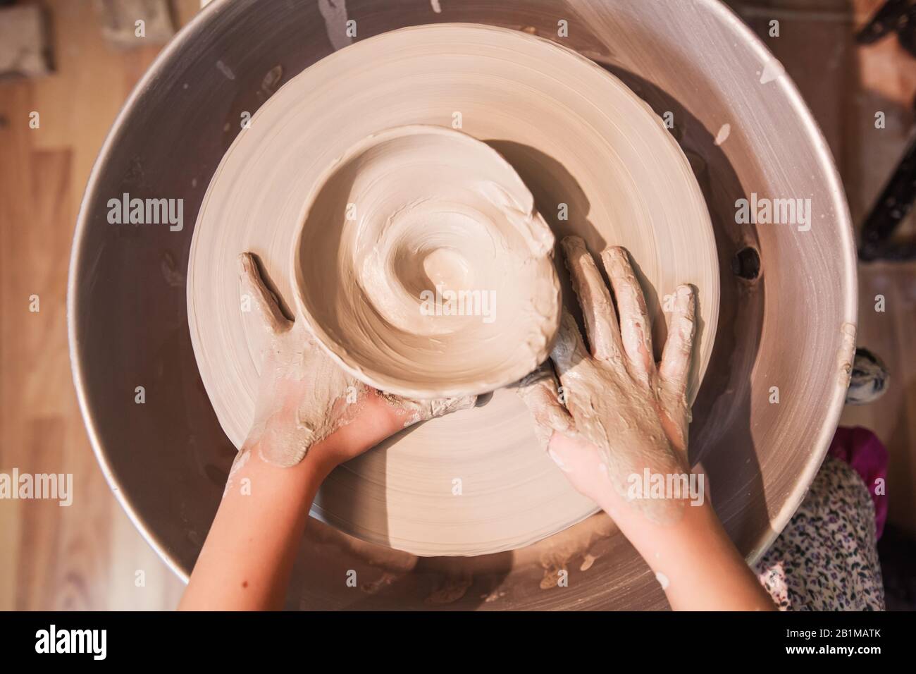 hands of young artist shaping clay on pottery wheel at workshop in ...
