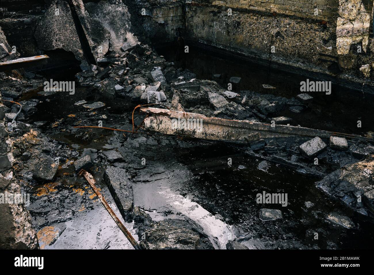 An exploded building with spilled oil or fuel oil. Black liquid in a ...