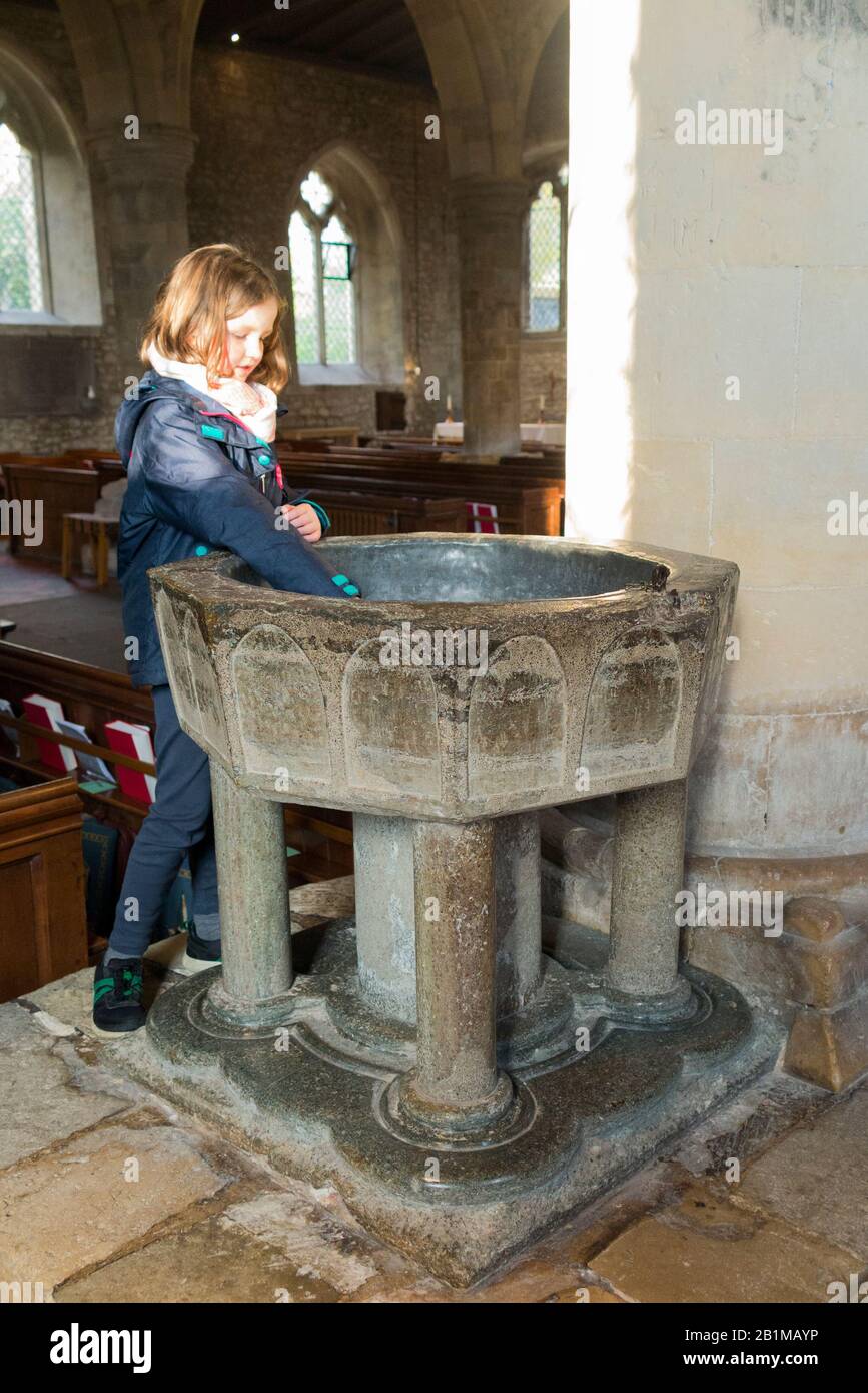 Seven-year-old girl child examines the late Norman 12th century stone ...