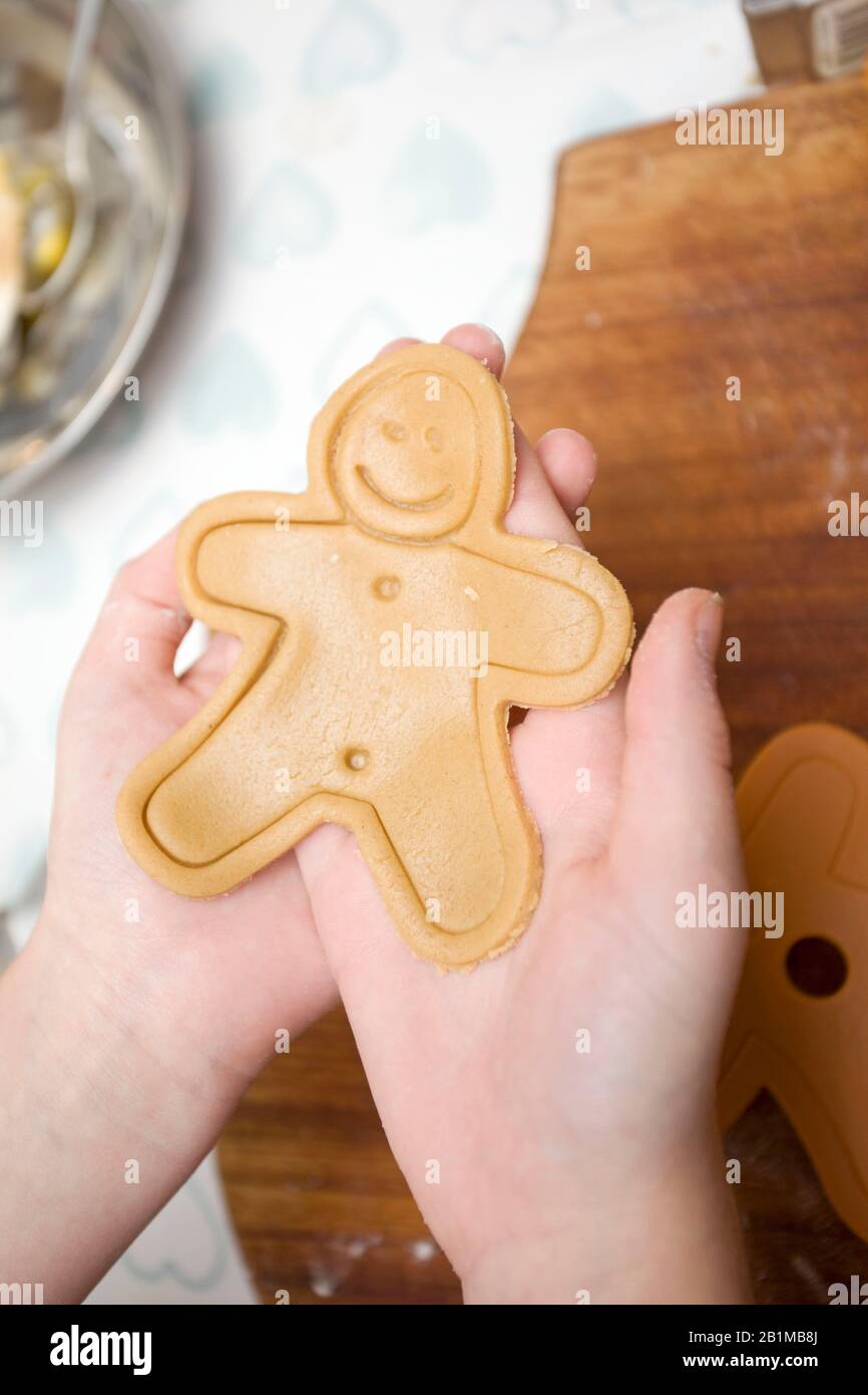 Child holding uncooked smiling gingerbread man Stock Photo - Alamy