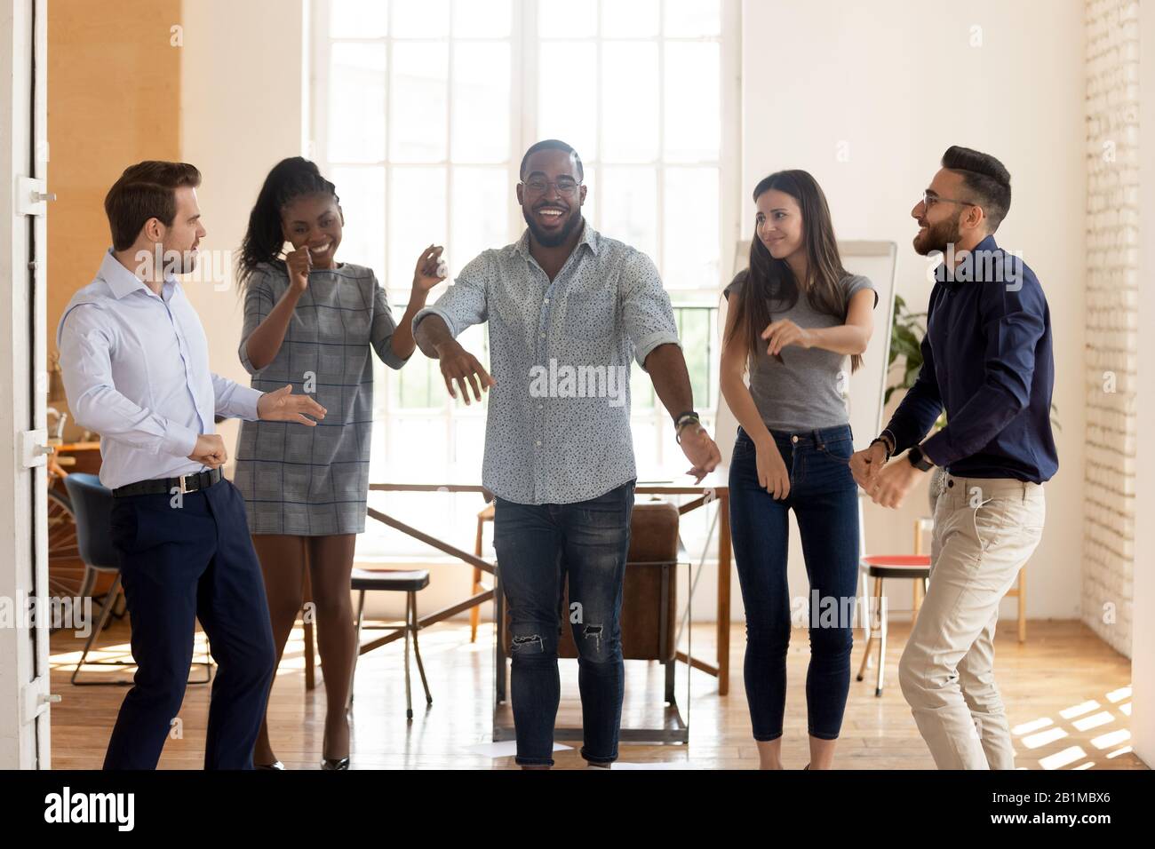 Active happy diverse businesspeople feels happy dancing in office Stock ...