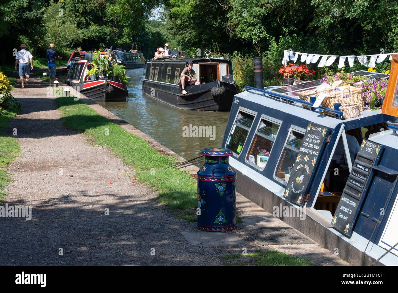 Canal boat travelling along the Oxford canal and passing a cafe on a ...