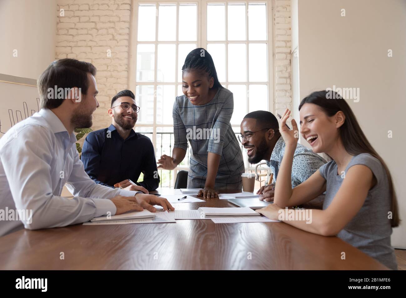 Staff take part in briefing lead by african female boss Stock Photo - Alamy