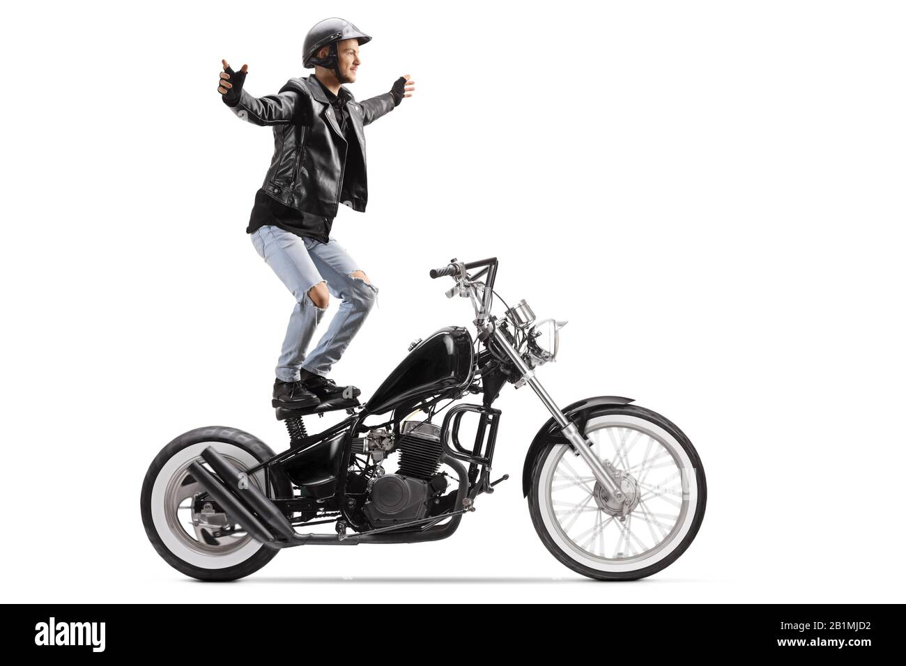 Daredevil riding a customized motorbike and standing on the seat ...