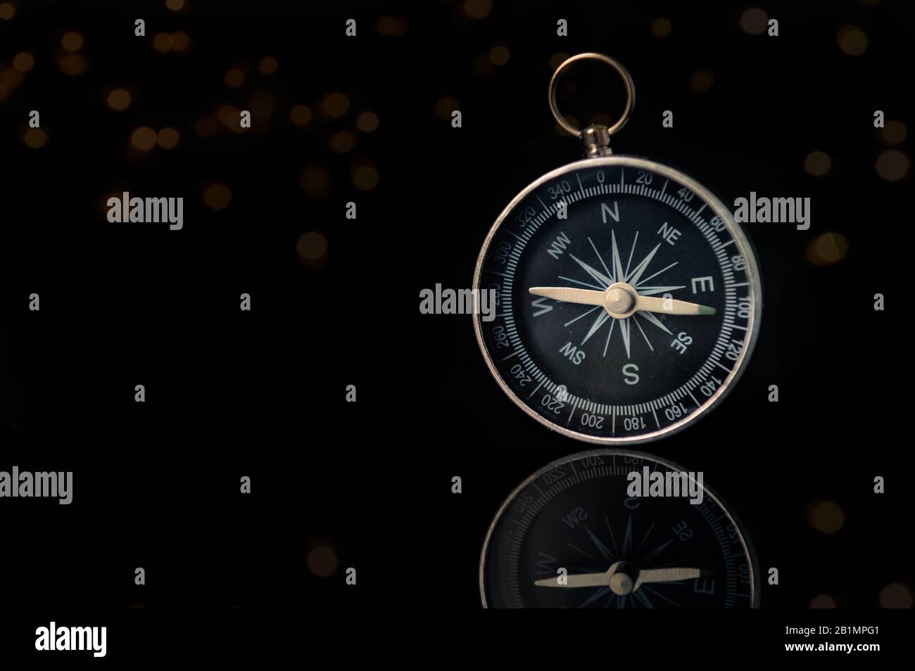 Compass on dark black background with copy space using as direction ...