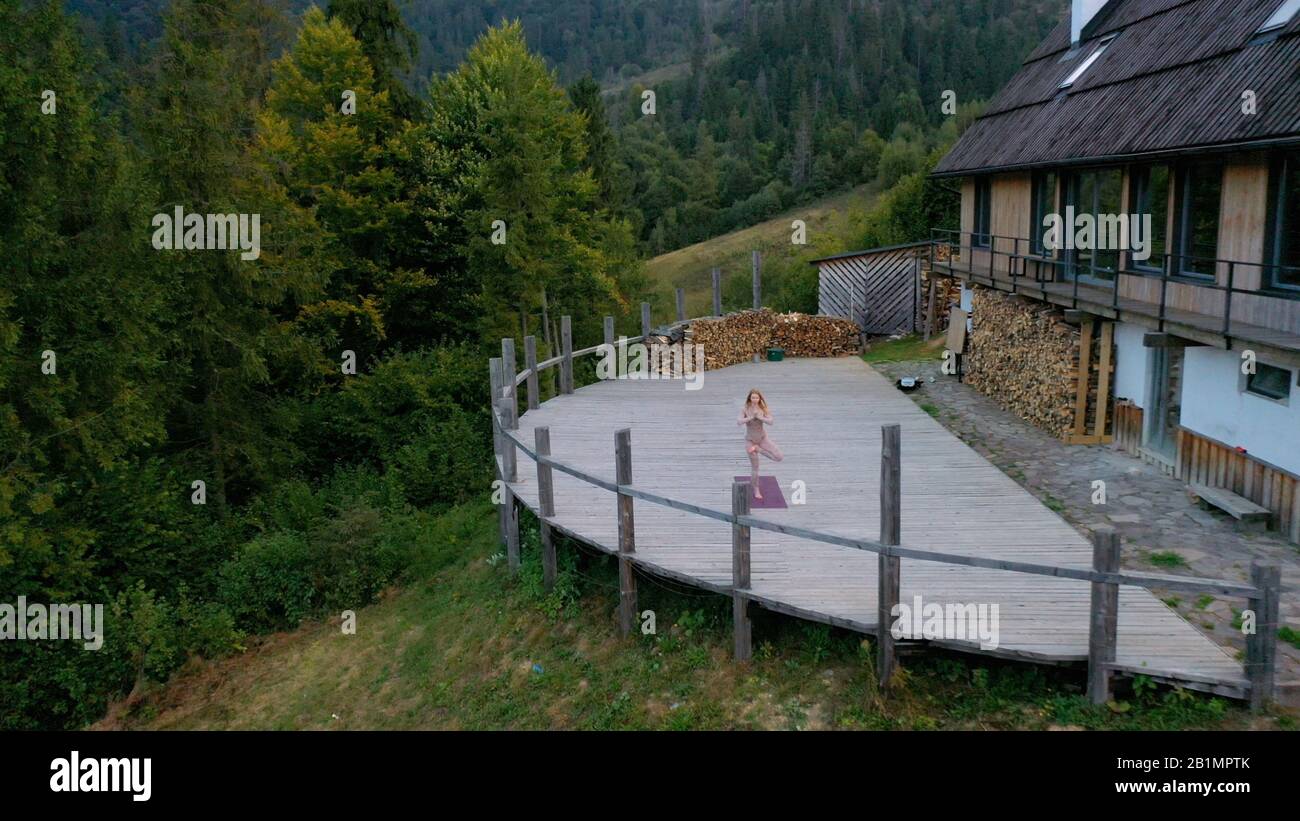 A woman practices yoga at the morning in a terrace on a fresh air Stock ...