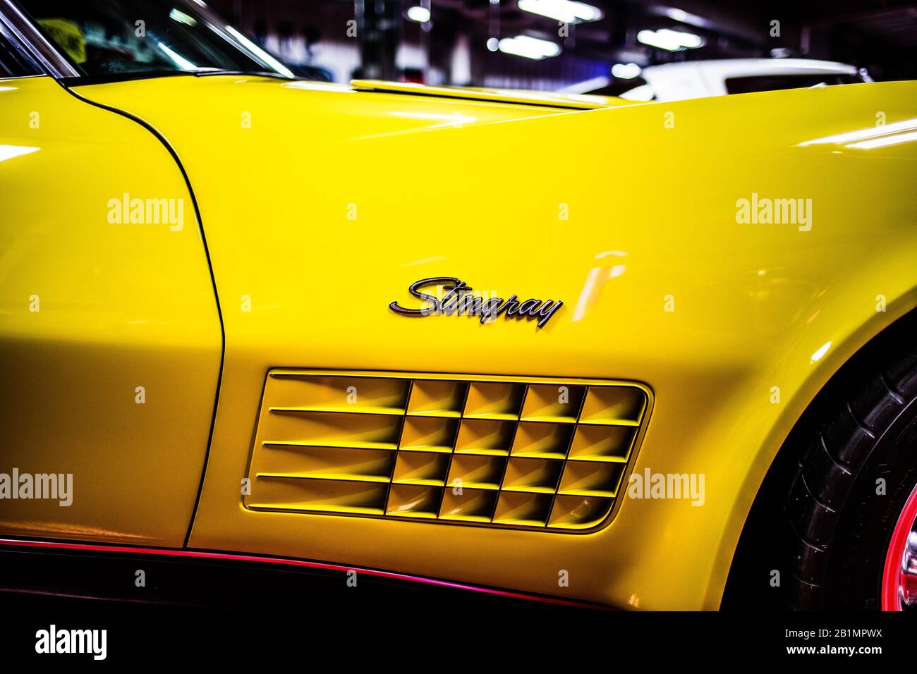 A beautiful yellow corvette with the Stingray logo on the side Stock ...