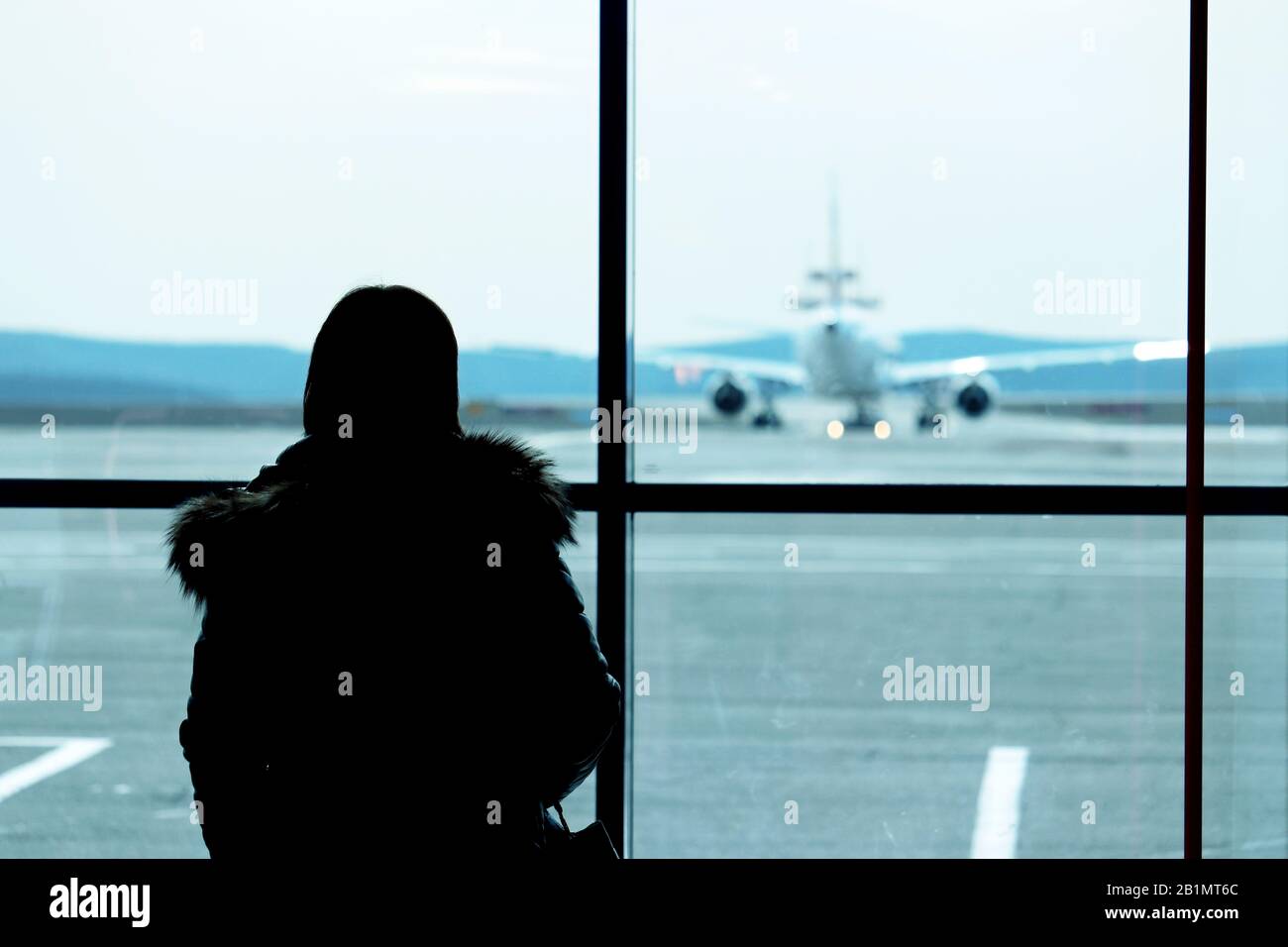Woman looking through window of plane hi-res stock photography and ...