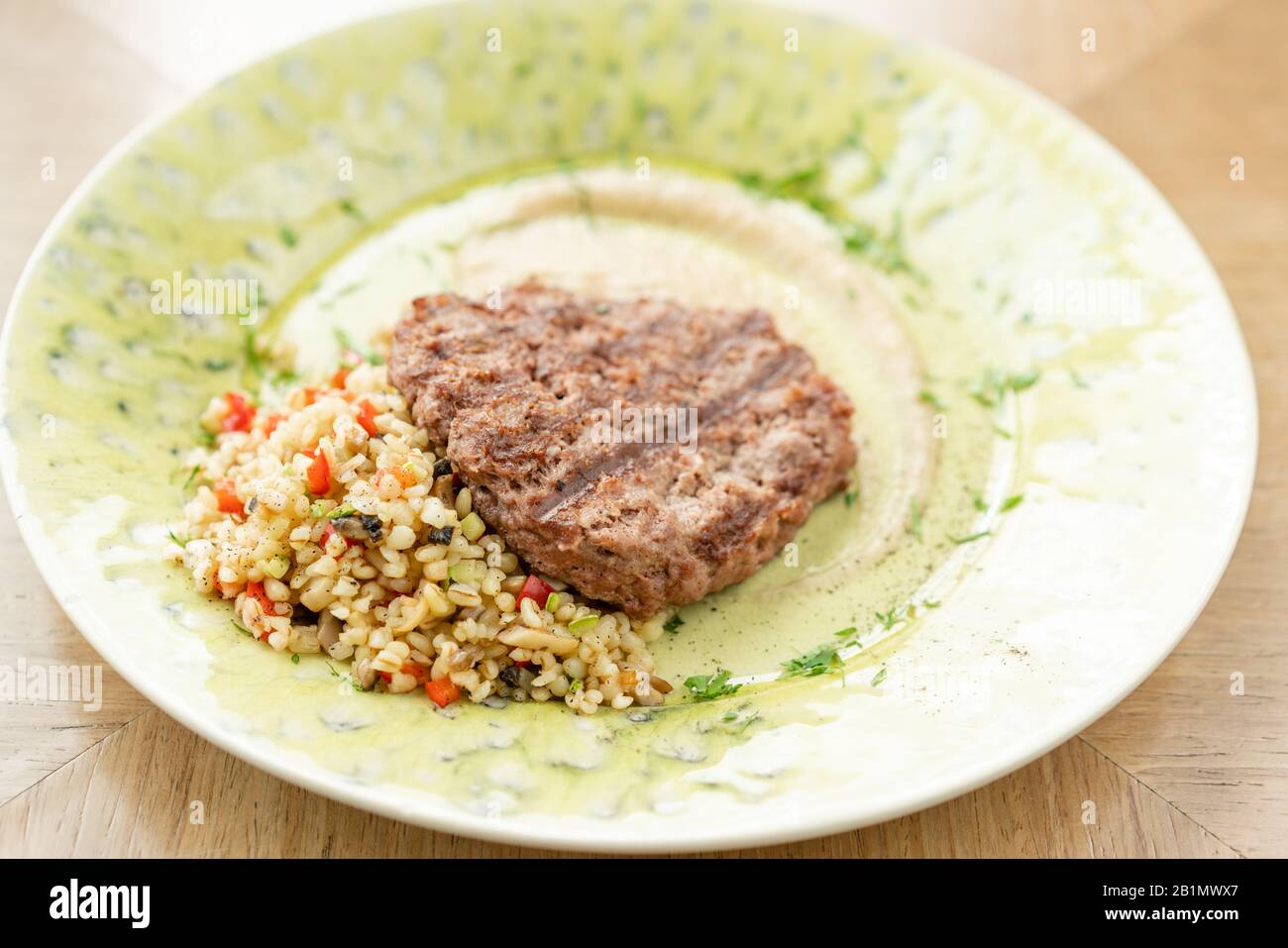Plate with Beefsteak marbled beef, served with bulgur and smoked onion ...