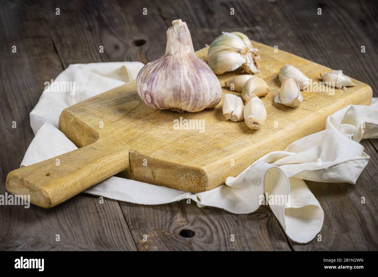 Still life with garlics on rustic wood table Stock Photo - Alamy