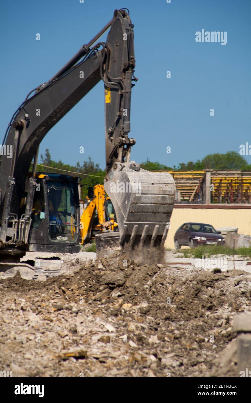 A large construction excavator of yellow color on the construction site ...