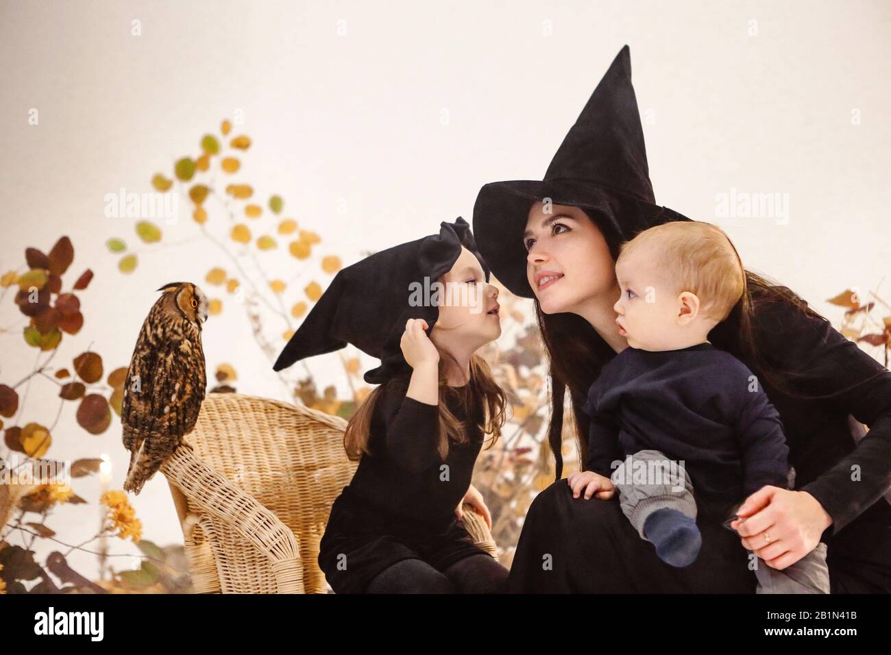 Happy mother and kids wearing spooky black costumes of witches in ...