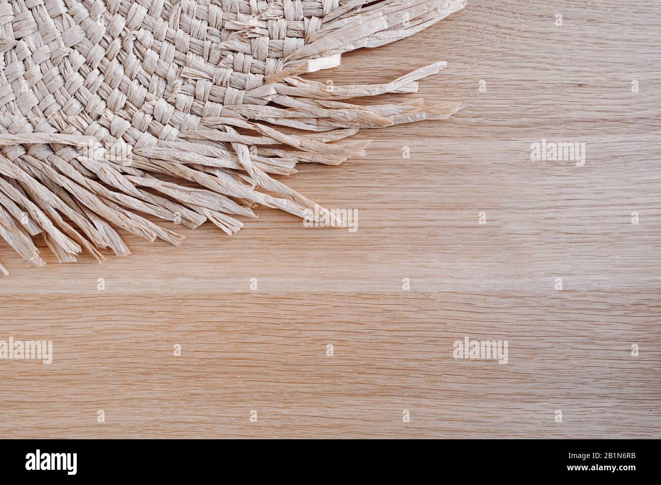 Layout background wicker straw napkin with fringe on a beautiful wooden ...