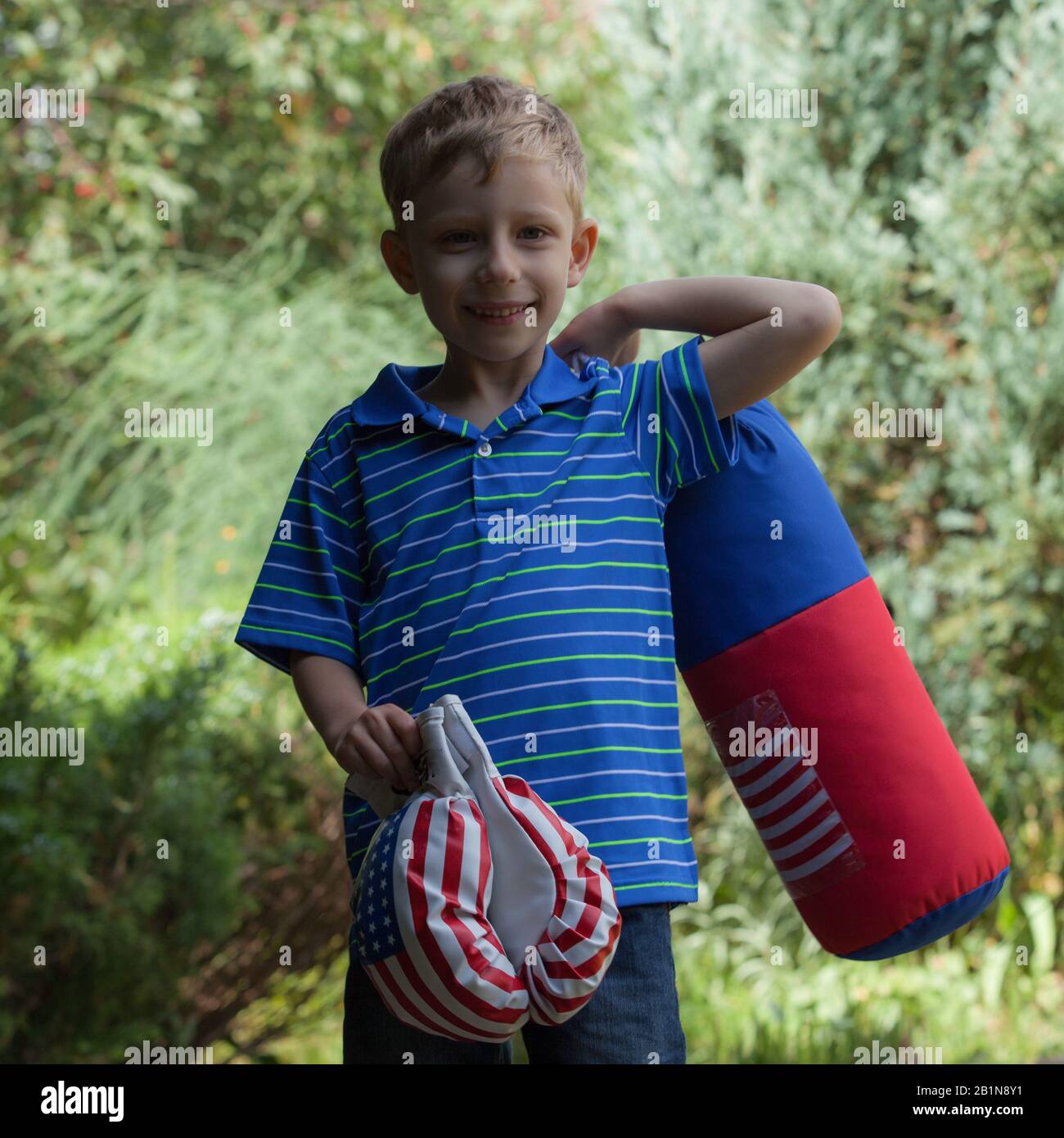 Cute fair-haired boy is playing outside Stock Photo - Alamy