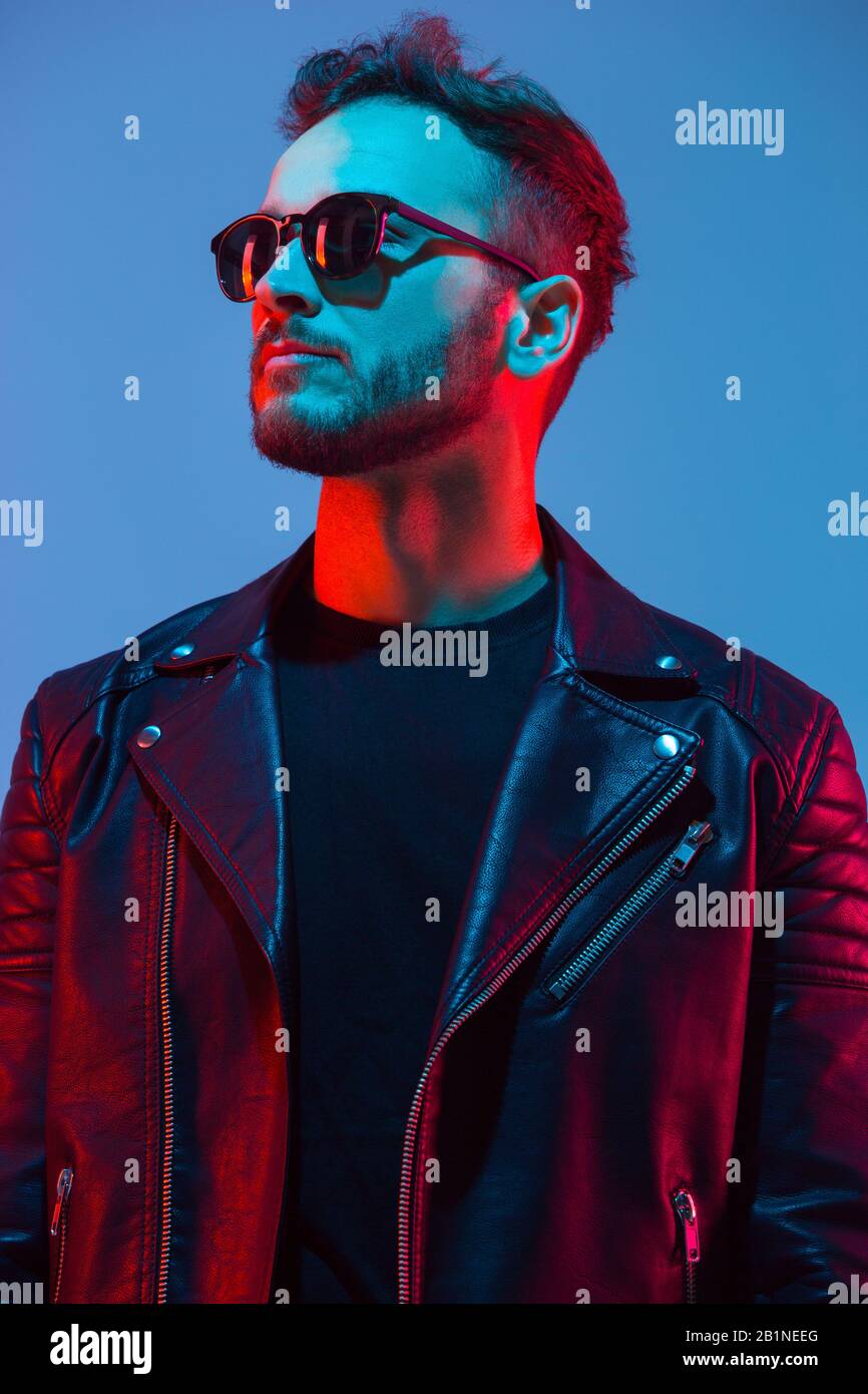 Young talented musician. Caucasian man's portrait isolated on blue ...