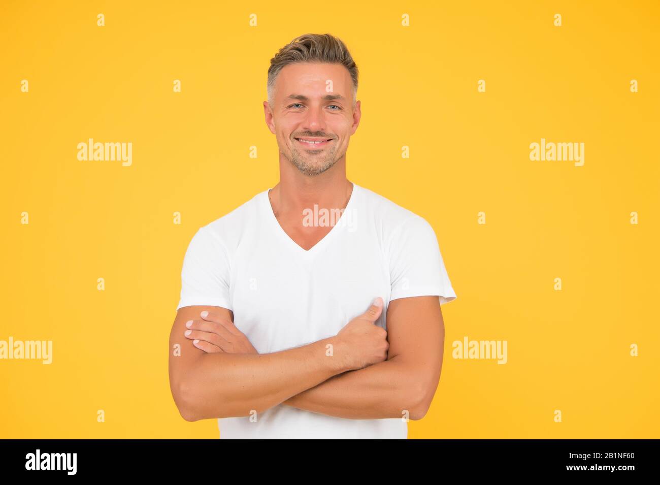 Confident and optimistic. Confident man with crossed arms yellow ...