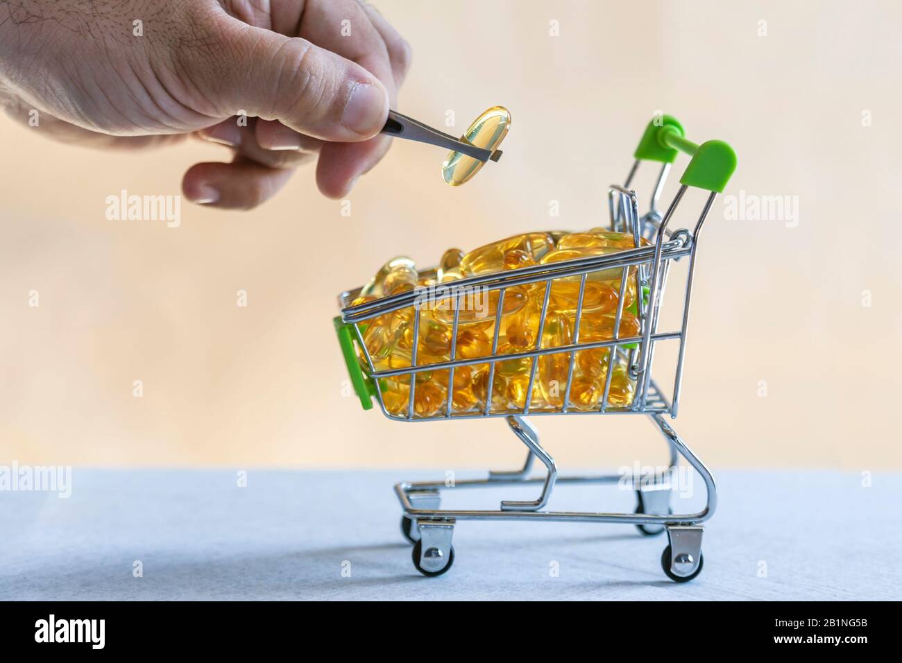 Hand picking up omega capsule hi-res stock photography and images - Alamy