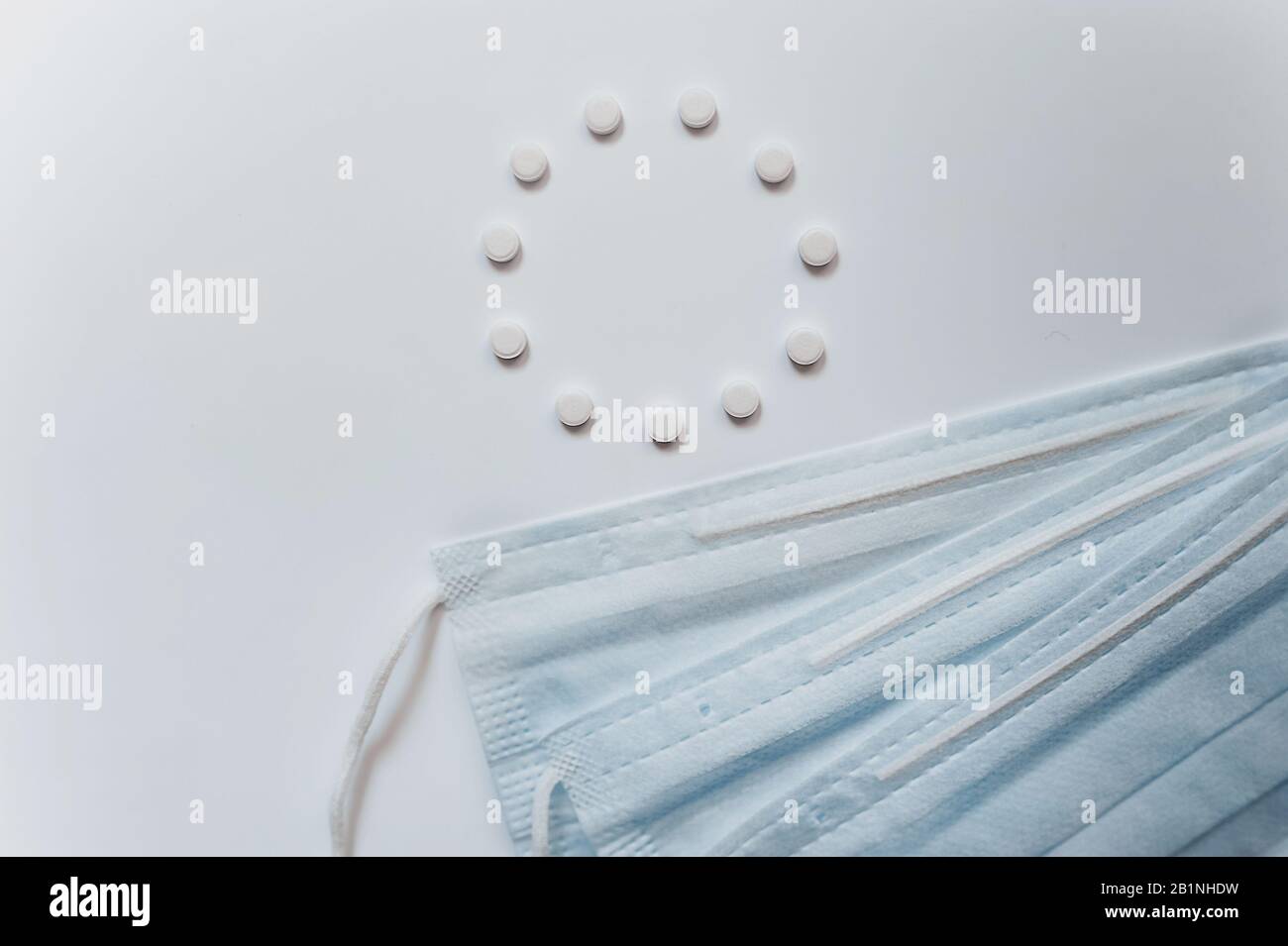 a circle figure made of small white tablets and three blue medical ...
