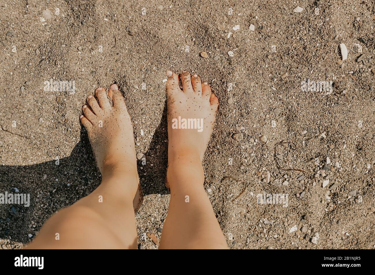 top view of the smooth legs of a fair-skinned girl standing on white ...