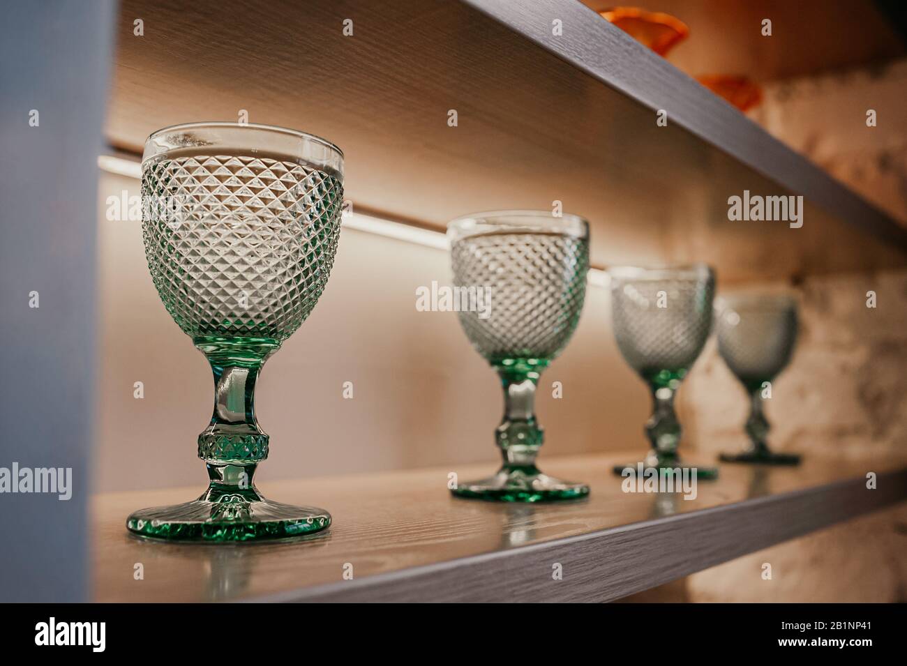 identical stylish textured green glass for drinks stand on wooden ...
