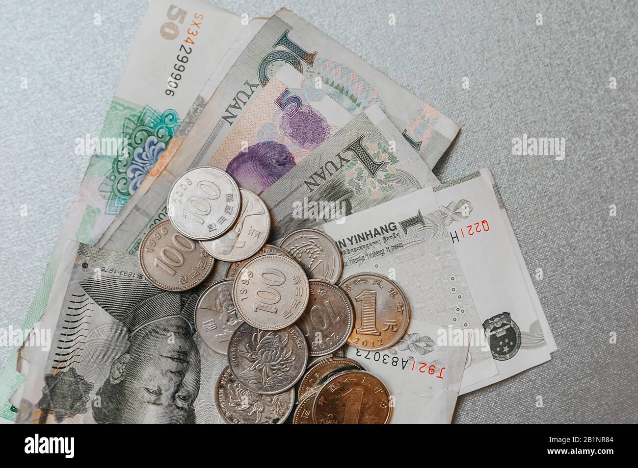 handful of silver Chinese coins and Chinese shabby yuan bank notes on a ...