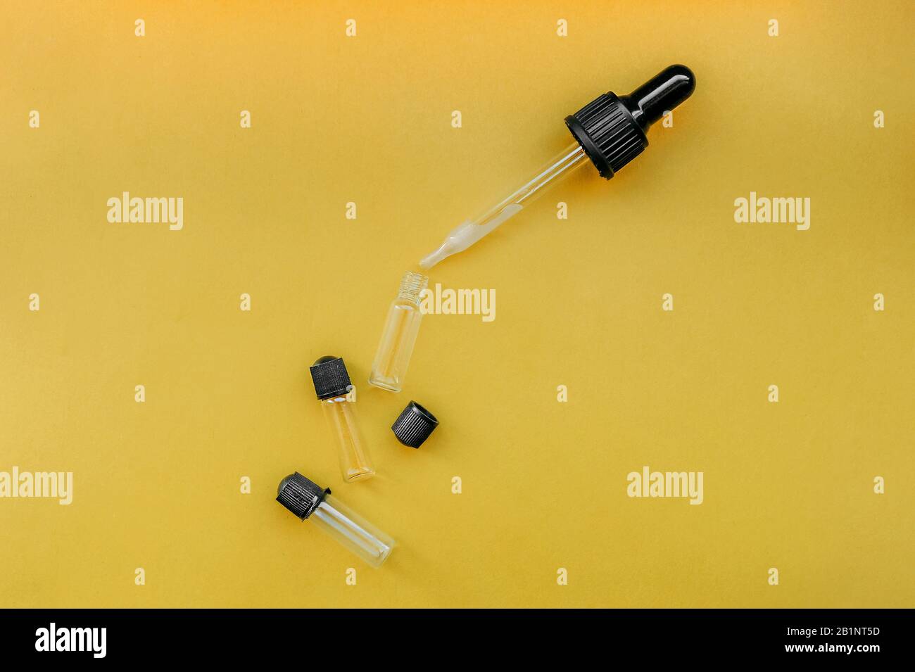 three small empty transparent jar with a black lid and the liquid is ...