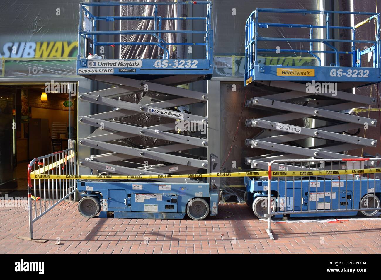 Two scissor lifts on the sidewalk Stock Photo - Alamy