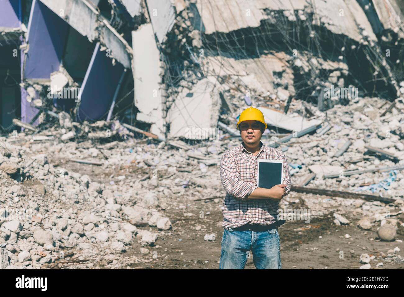 Engineer holding tablet is checking for destruction, demolishing ...