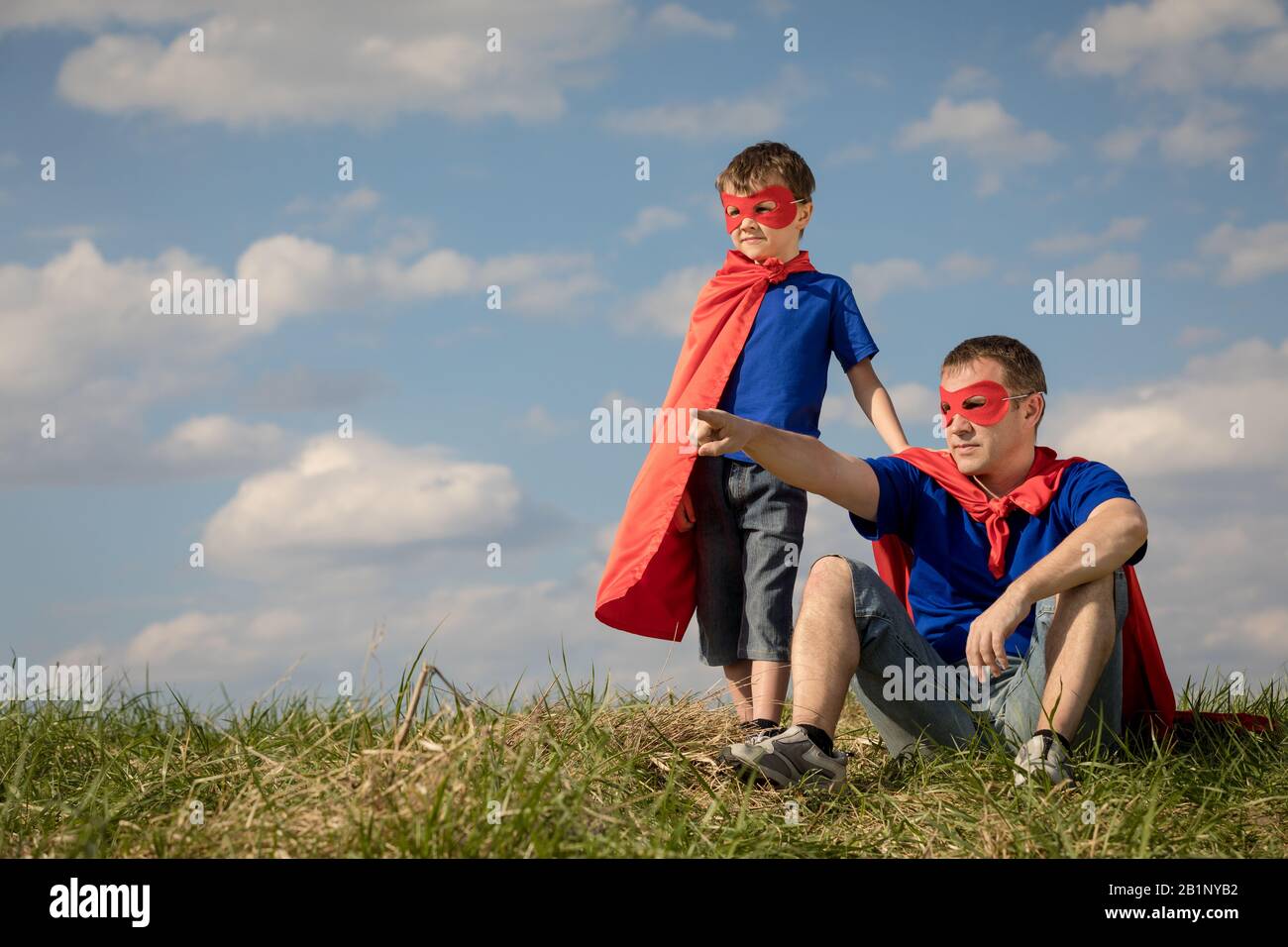 Father and son playing superhero at the day time. People having fun ...