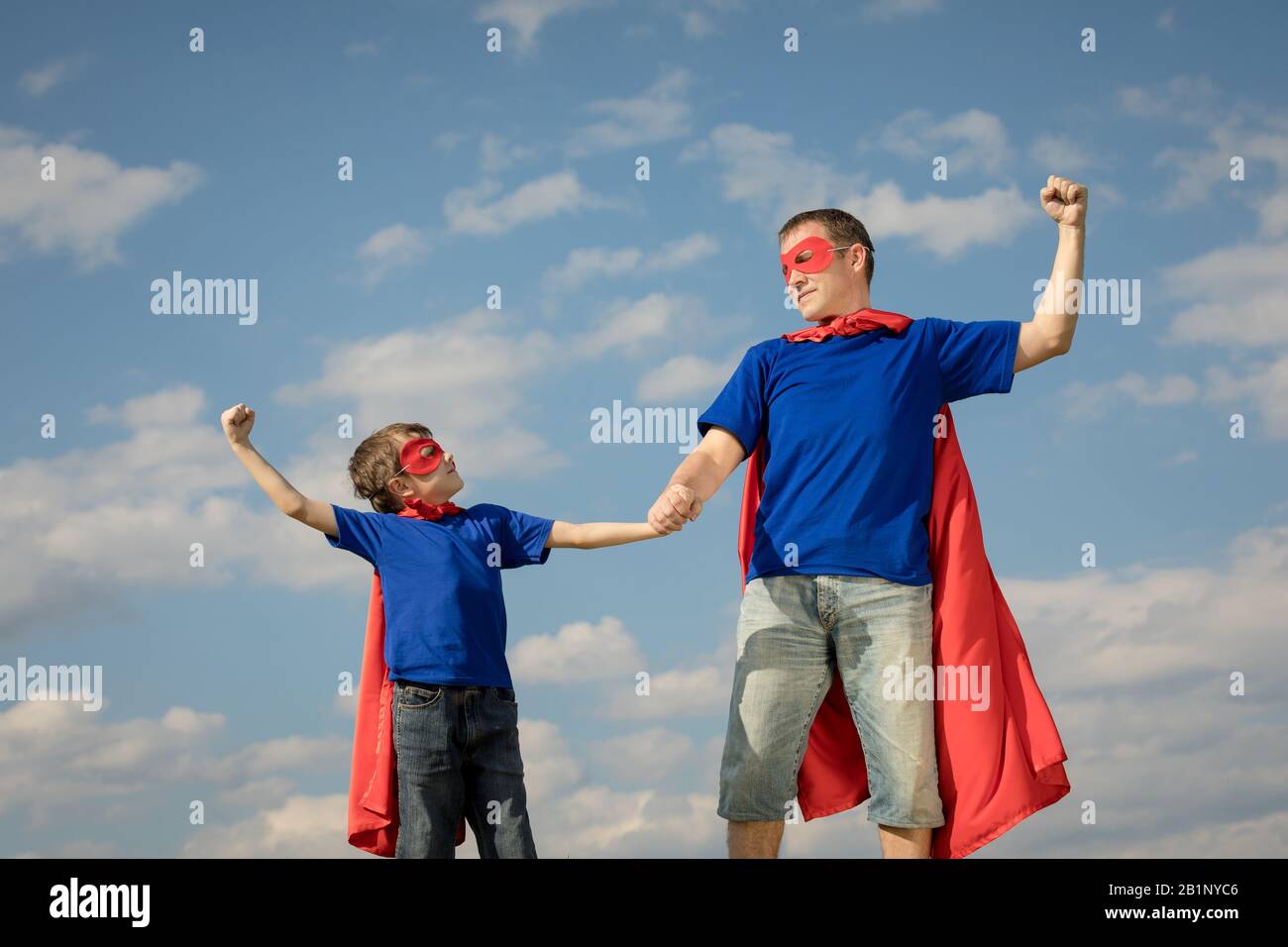 Father and son playing superhero at the day time. People having fun ...