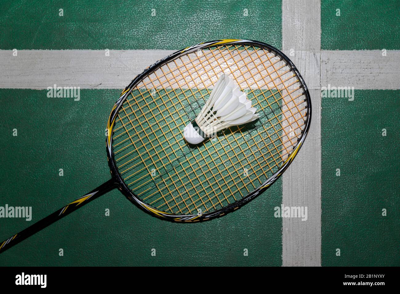 Top view of white badminton shuttlecock and racquet on wooden floor ...