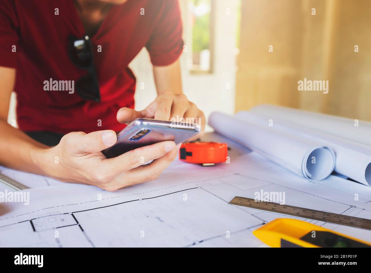 Engineer or Architect using cell phone on blueprint in building ...