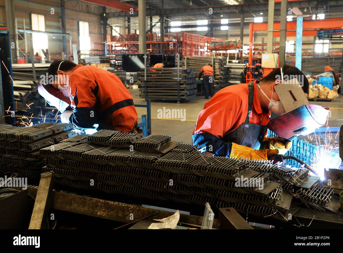 Chinese workers weld steel beams at a plant in Taicang City, east China ...