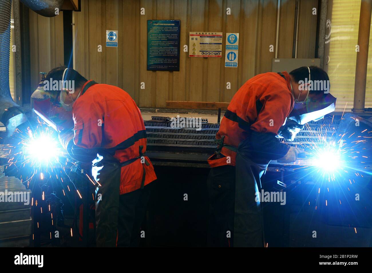 Chinese workers weld steel beams at a plant in Taicang City, east China ...