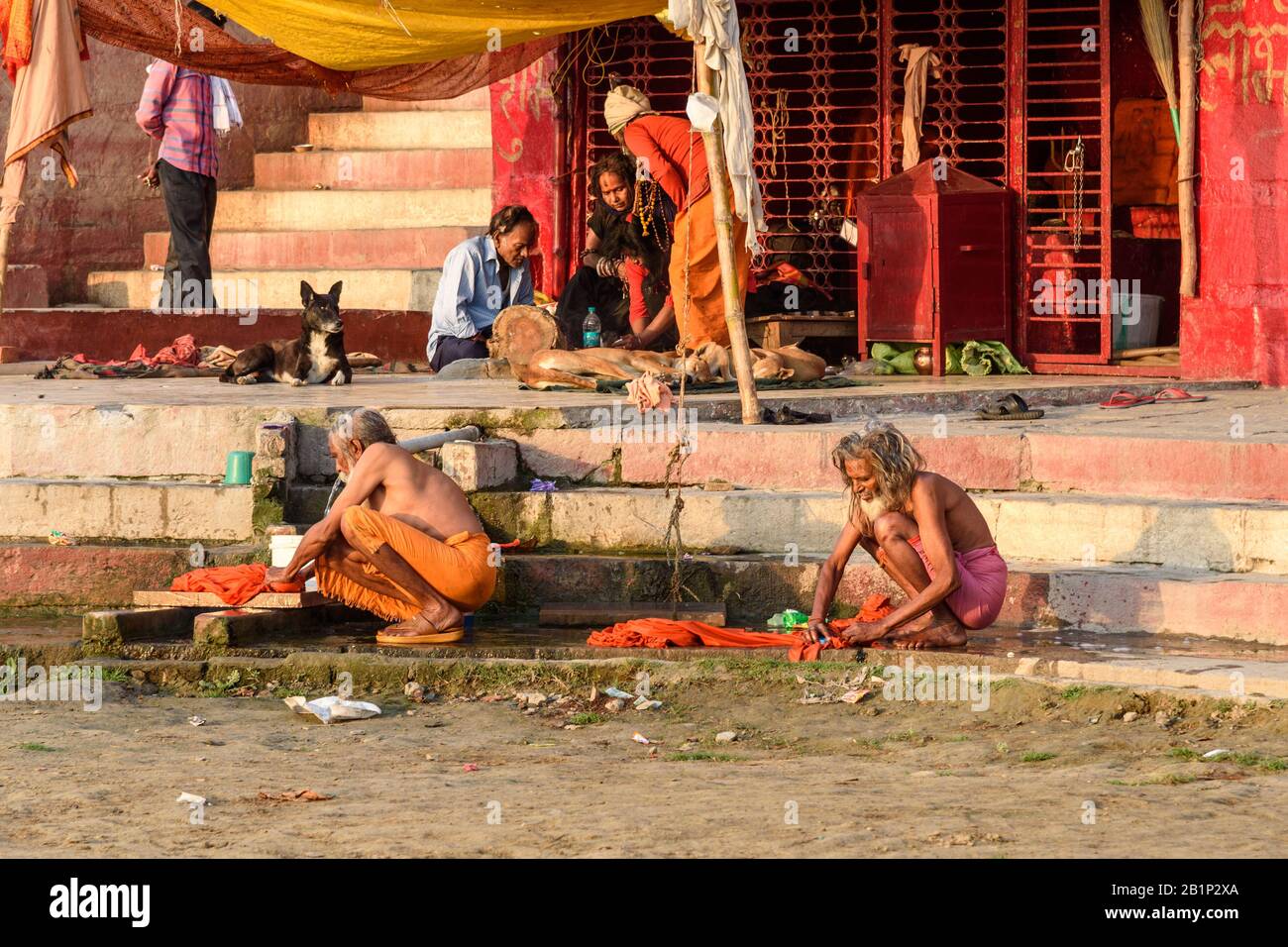 Sadhu holy men washing clothes on ghats in Varanasi. India Stock Photo ...