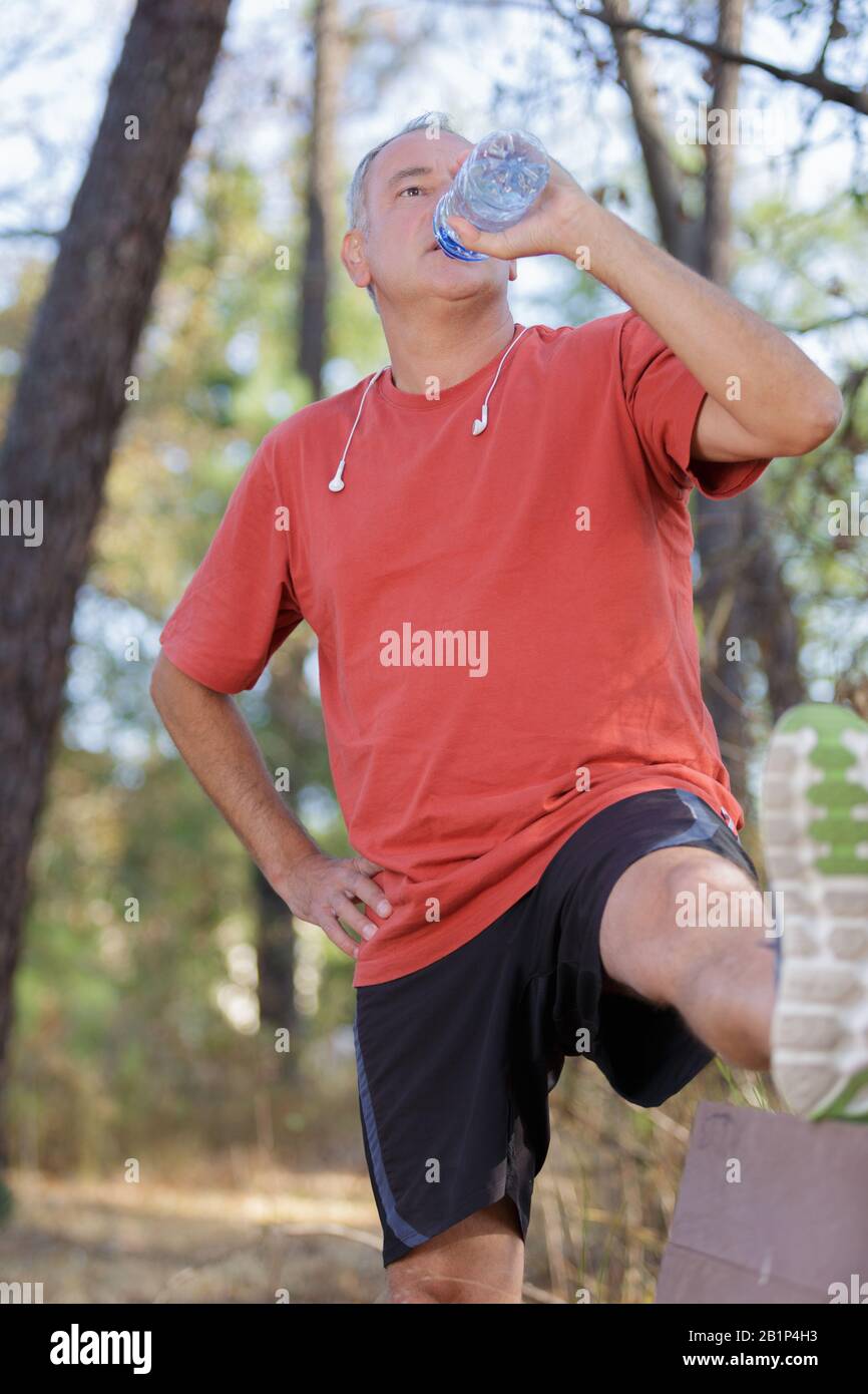 middle-age running man drinking water Stock Photo - Alamy
